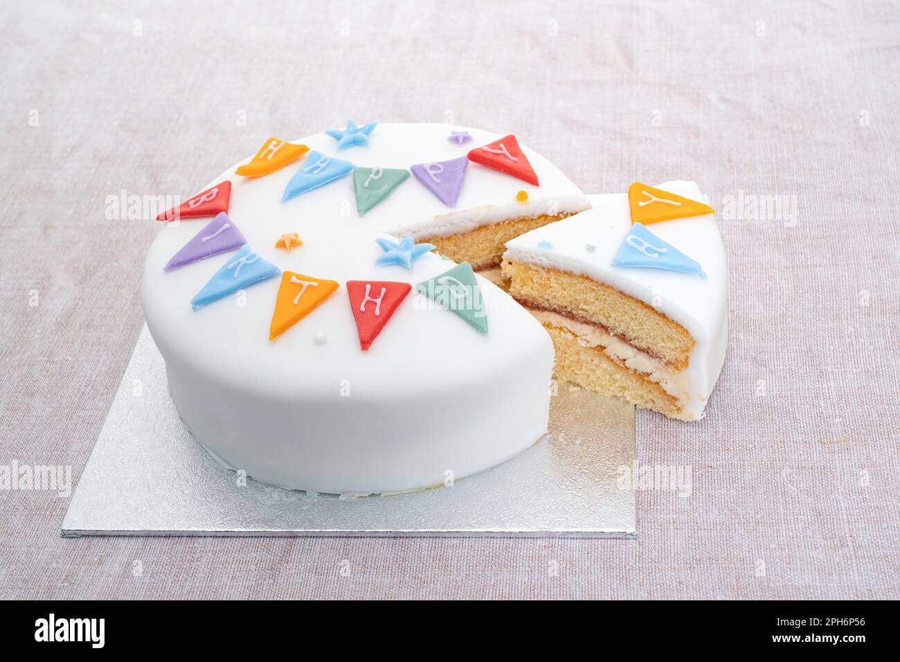Happy birthday cake with colourful letters with a slice cut out Stock ...