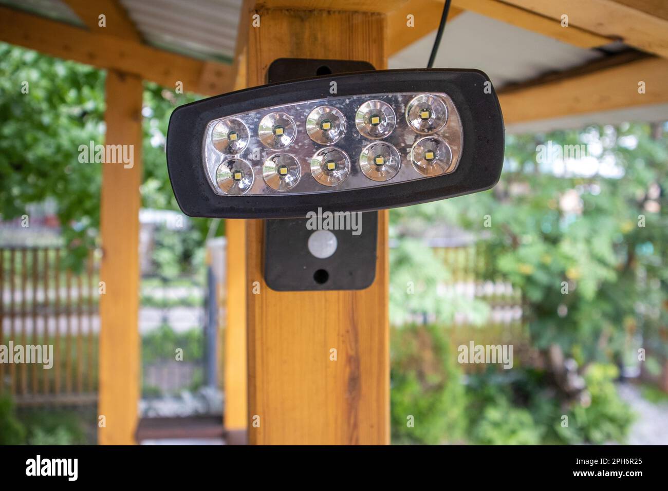 Close-up of an LED spotlight, a spotlight on a wooden post of an open ...