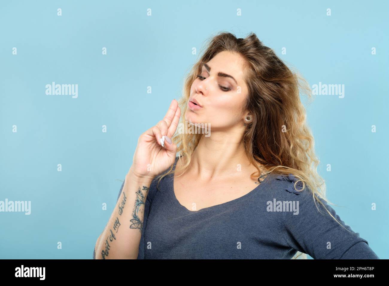 confident young woman finger gun hot blow air Stock Photo - Alamy