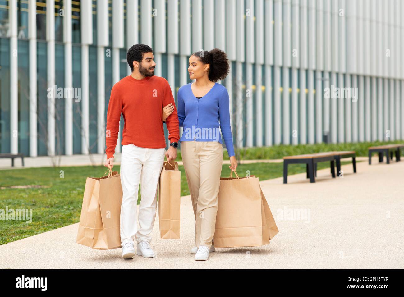 Happy Diverse Couple Walking Carrying Shopping Bags Together Outdoors ...