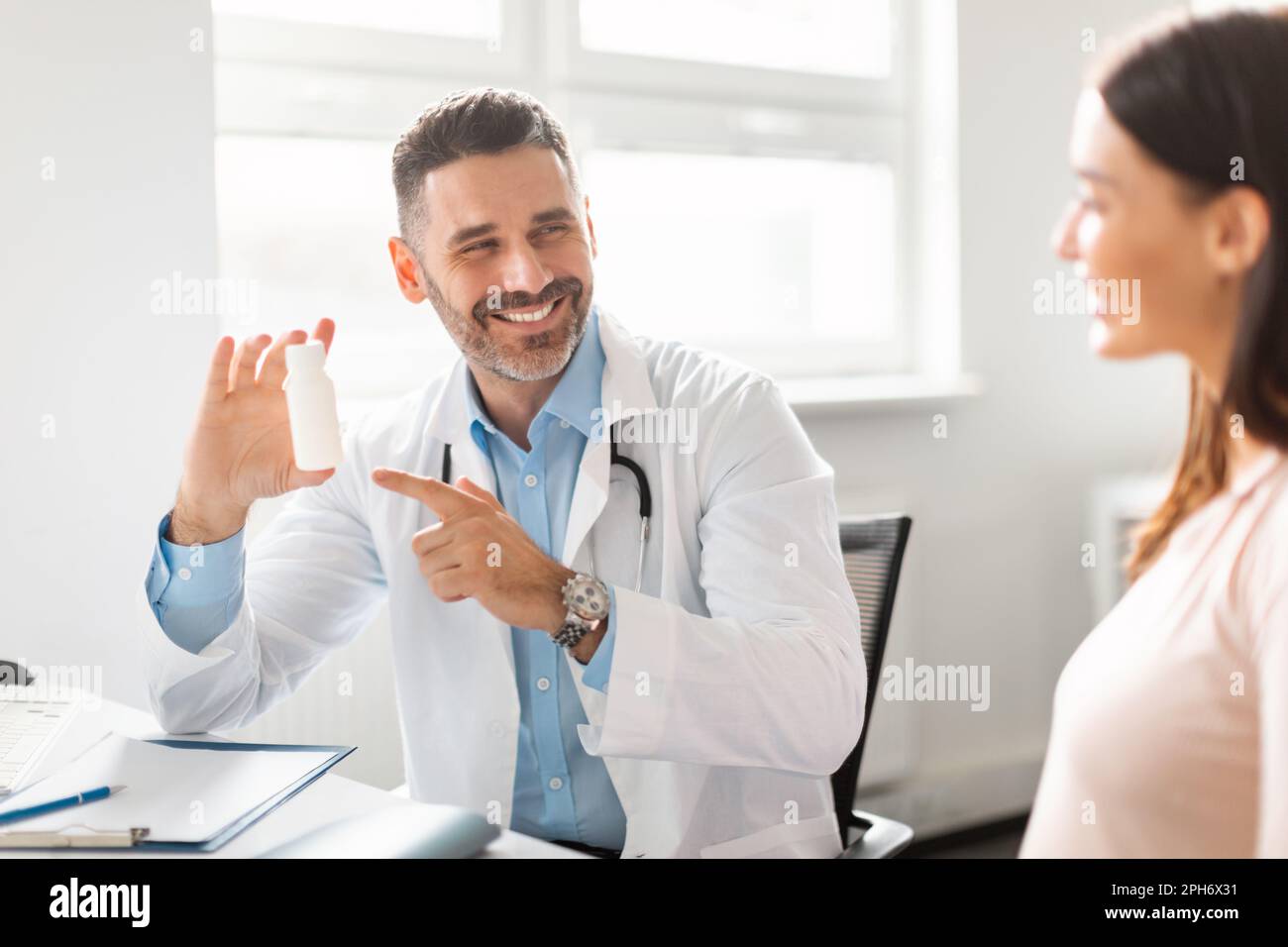Pharmaceutical drug prescription concept. Male doctor showing female ...