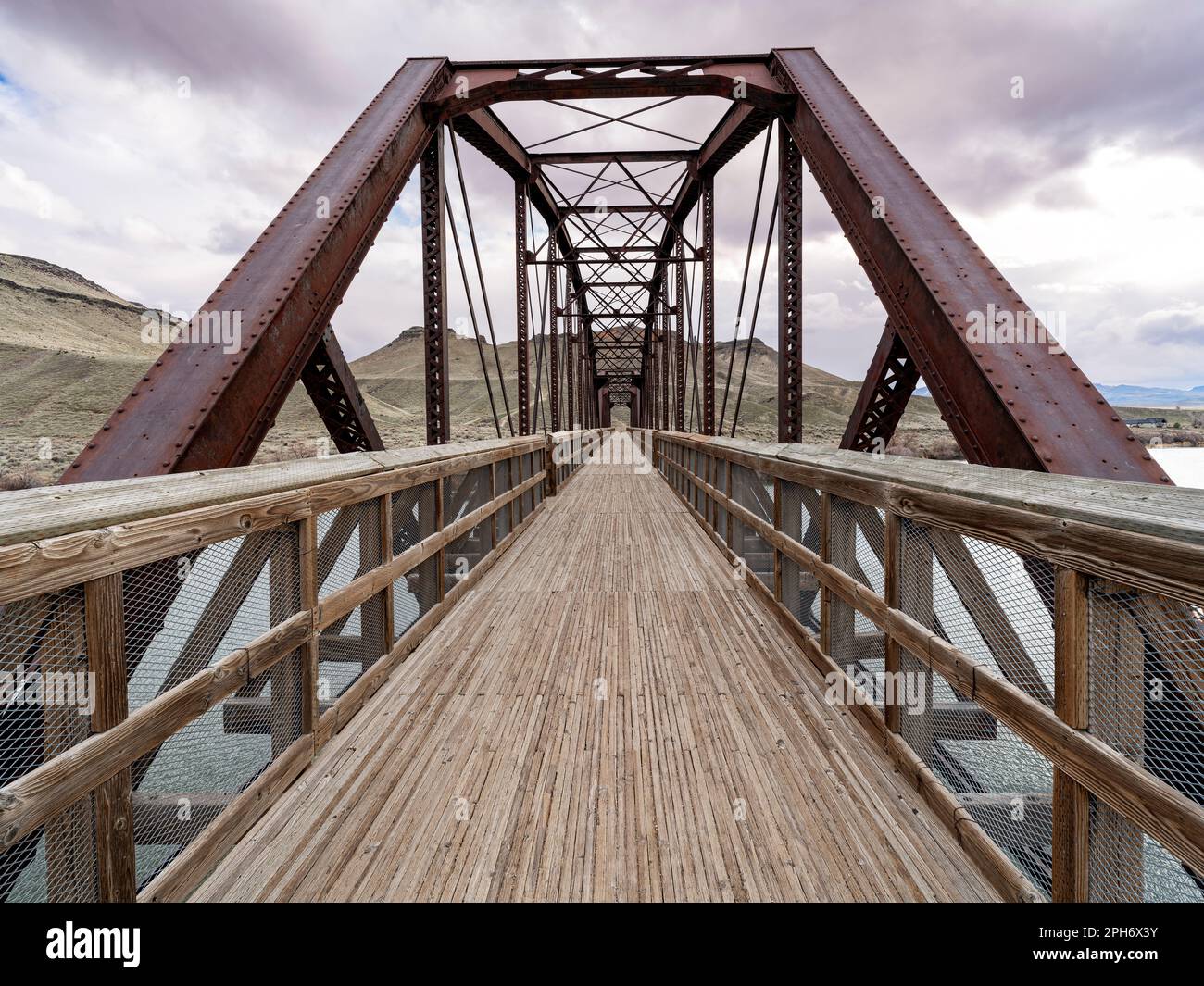 Iconic old bridge leads across wild river to the desert Stock Photo - Alamy