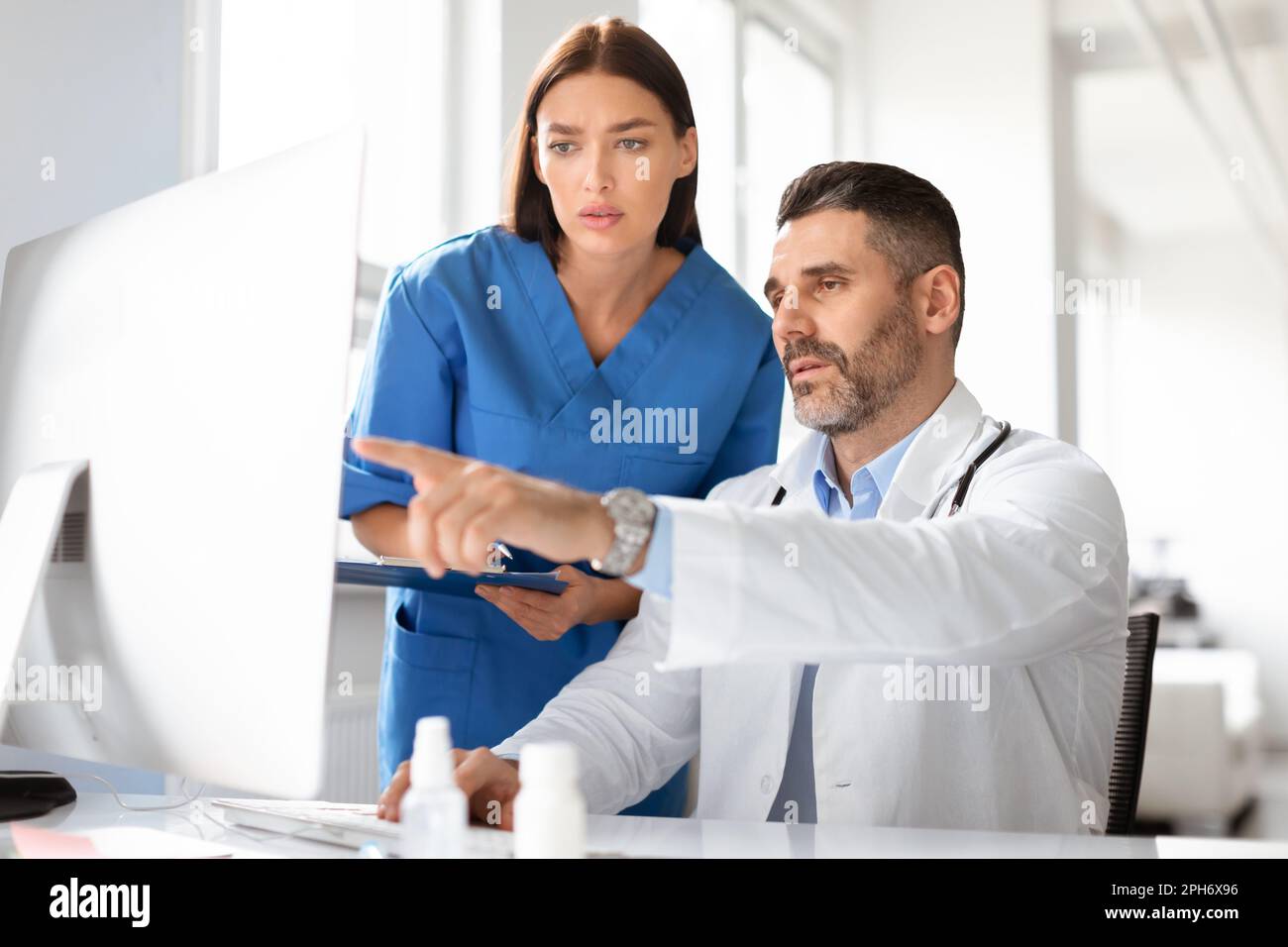 Male and female doctors team discussing patient diagnosis data, using ...