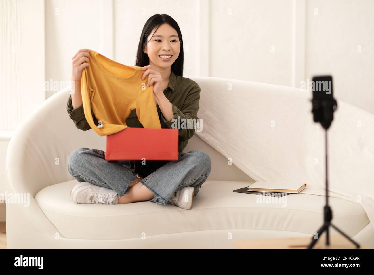 Female influencer young asian woman reviewing product cloth, streaming ...