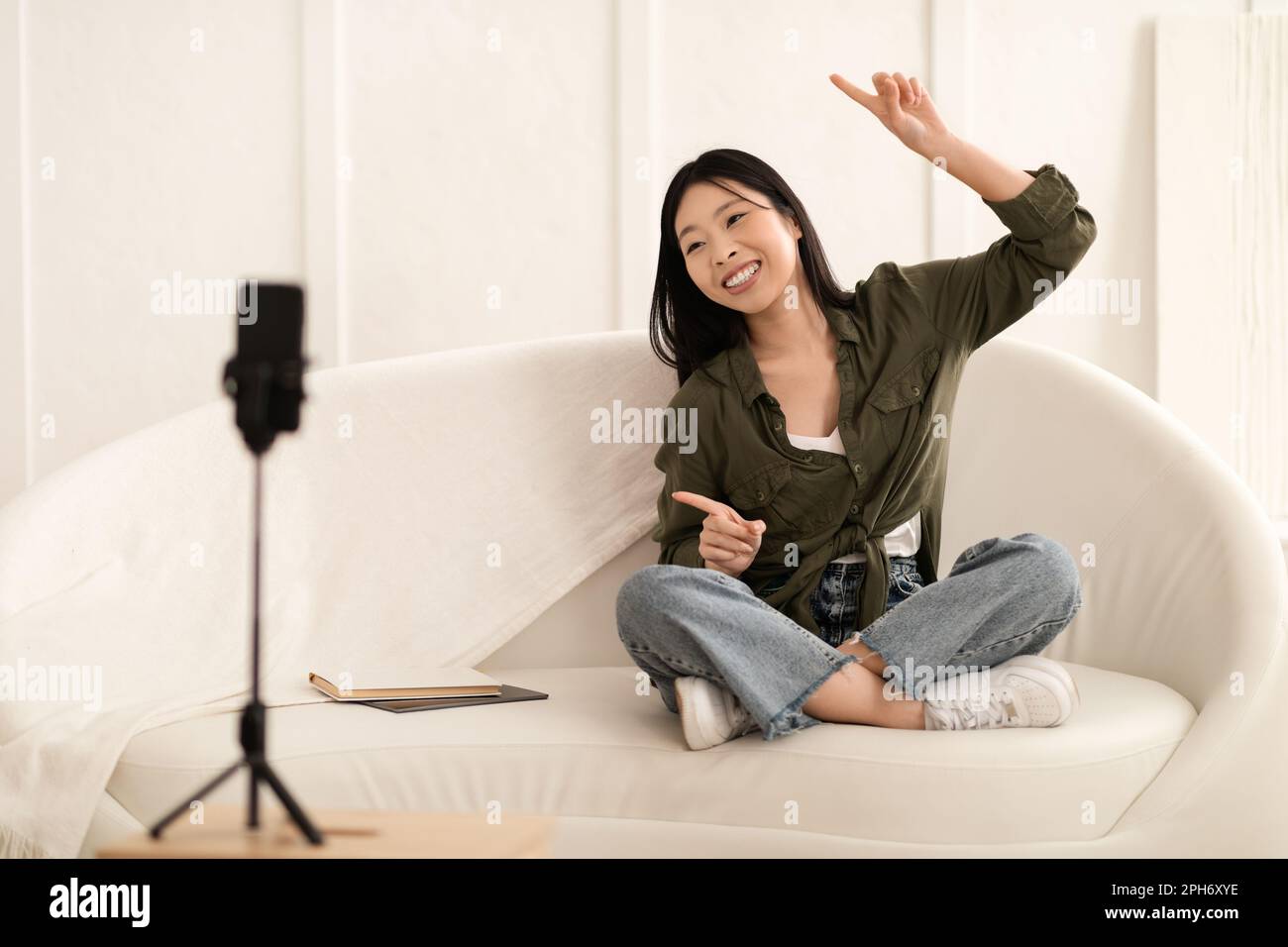 Cute asian female vlogger dancing, recording content for followers ...