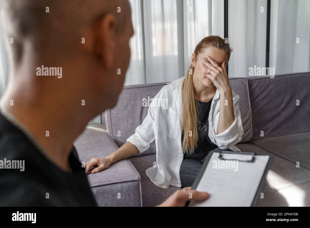 A male psychologist consults a female patient, makes notes. A woman ...