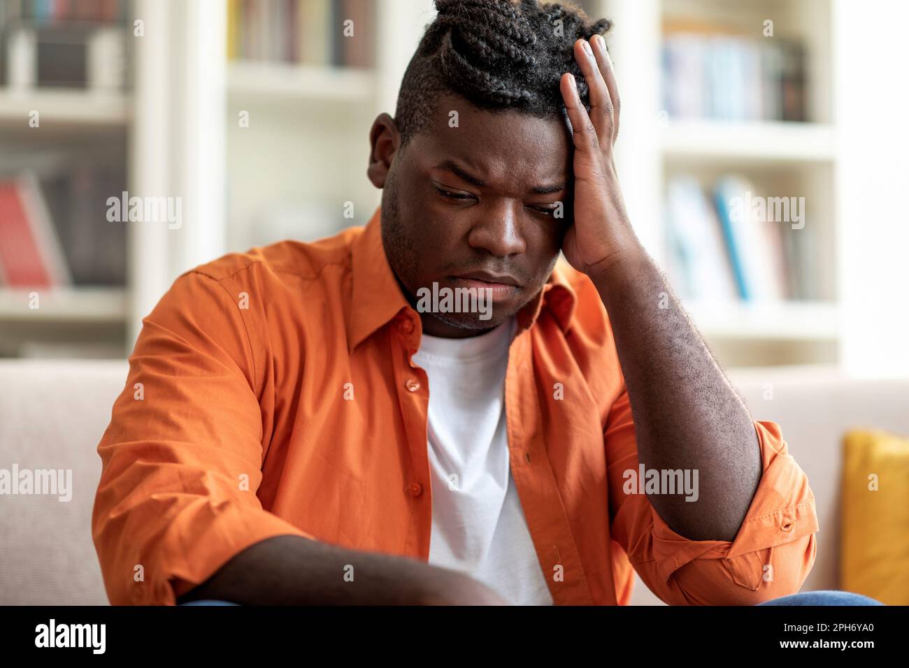 Frustrated african american guy siting on couch at home Stock Photo - Alamy