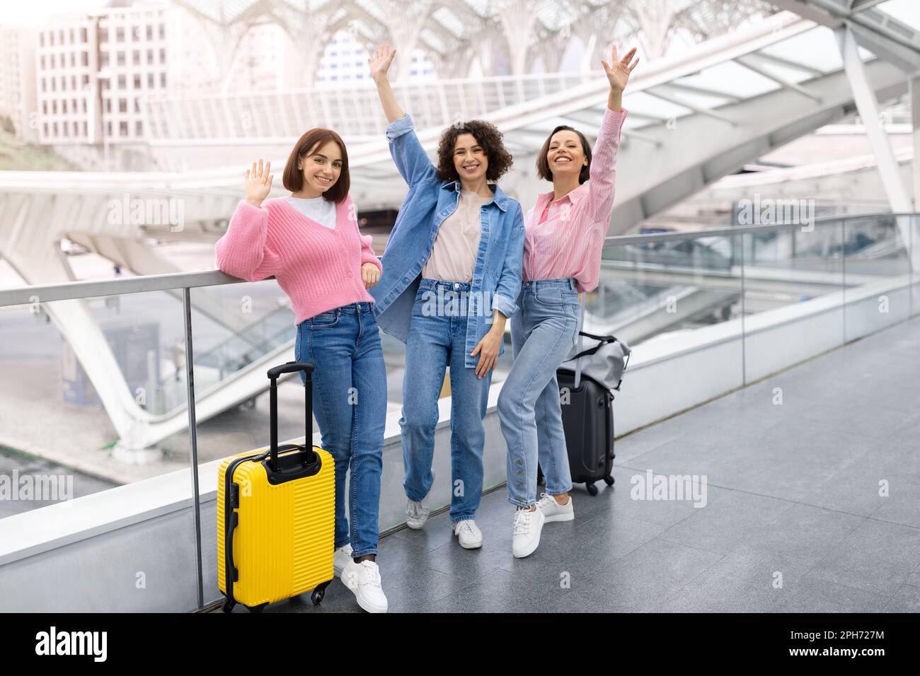 Three Happy Female Friends Waving Hands At Camera While Posing At ...