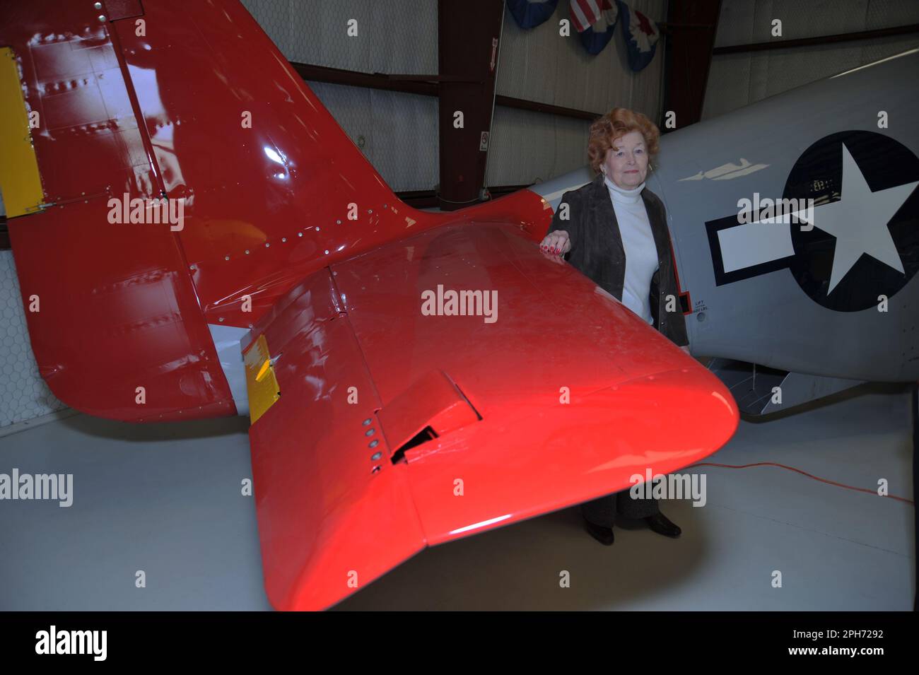 WWII Rosie the Riveter standing by an airplane she help build during ...
