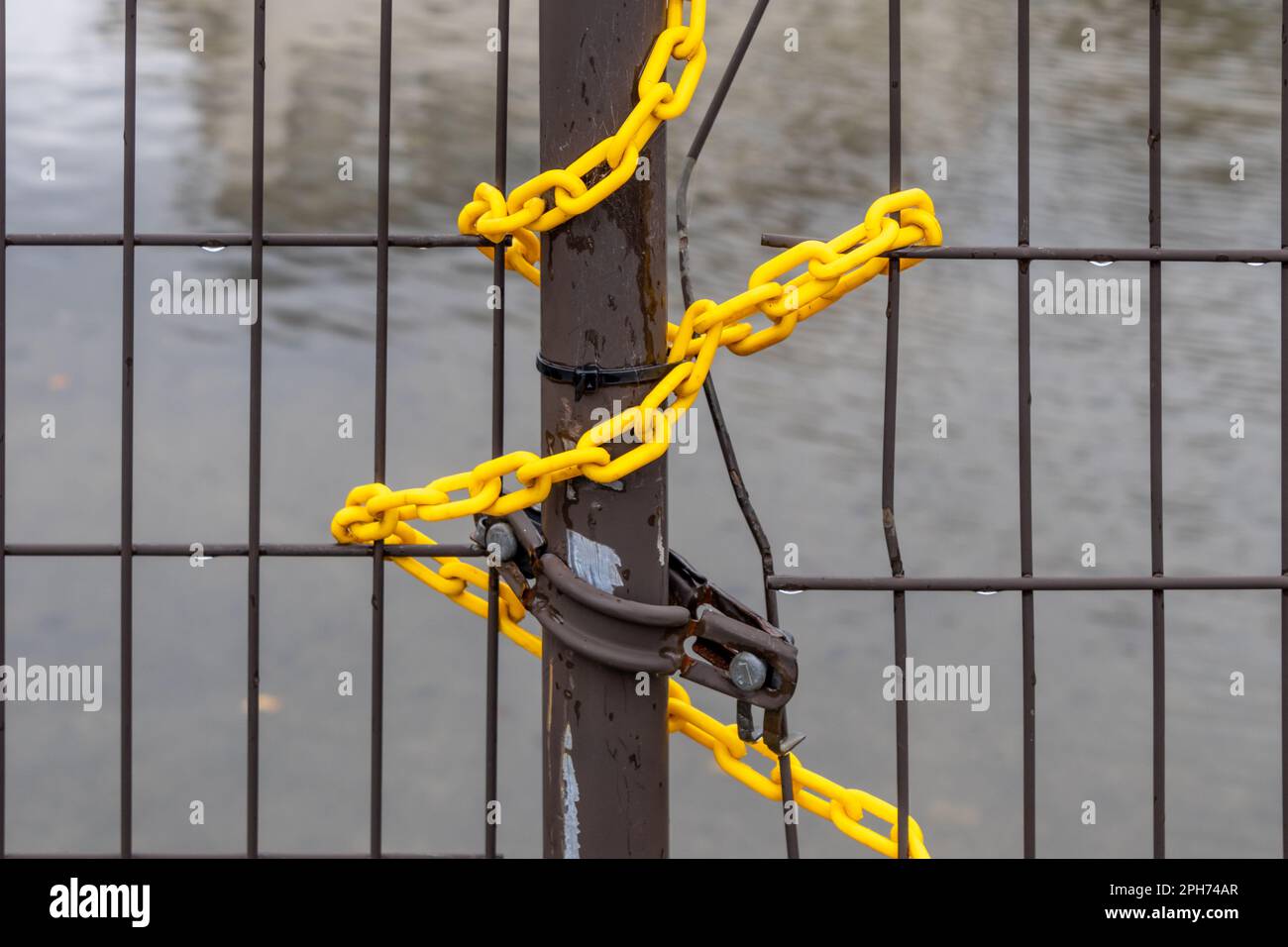 Yellow plastic chain on metal gate, with water in background, Kanazawa ...