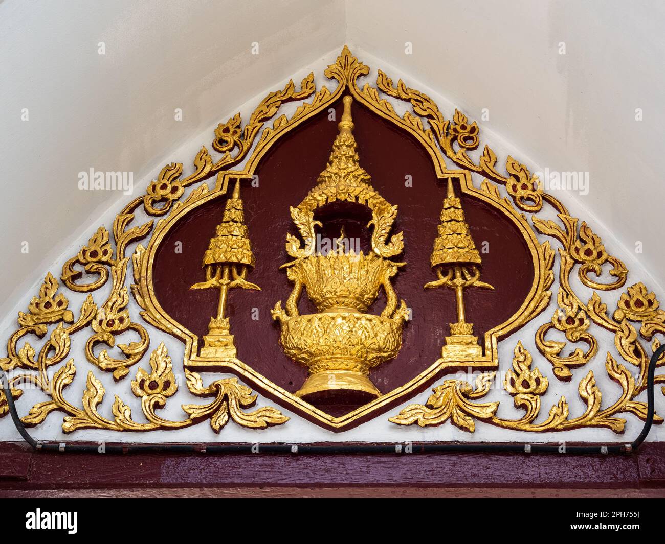 Intricate gold ornaments on a red and white background above a door in ...
