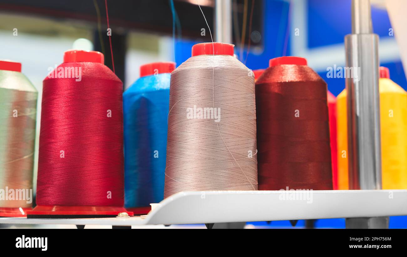 Reels of textile yarn multicolor thread at industrial weaving ...