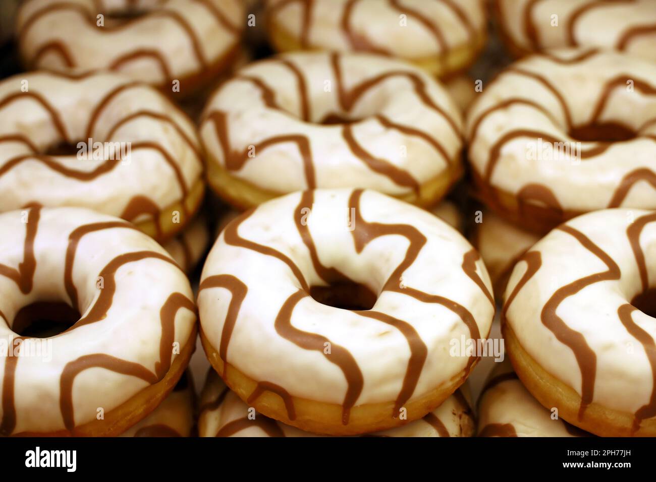 Doughnuts in white glaze close up. Sweet donuts in a store, high ...