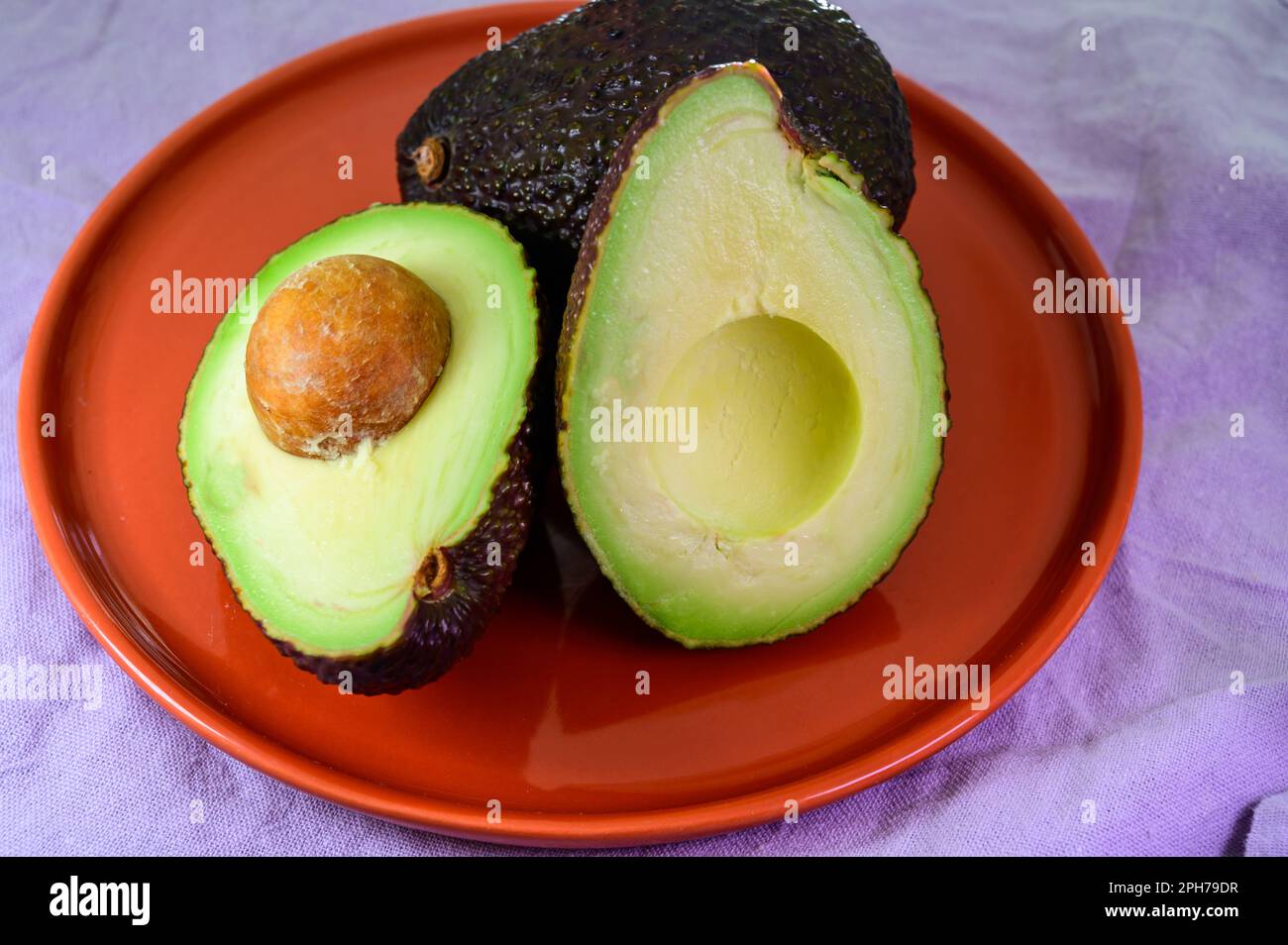 Two fresh ripe raw hass avocados, close up, healthy food concept close ...