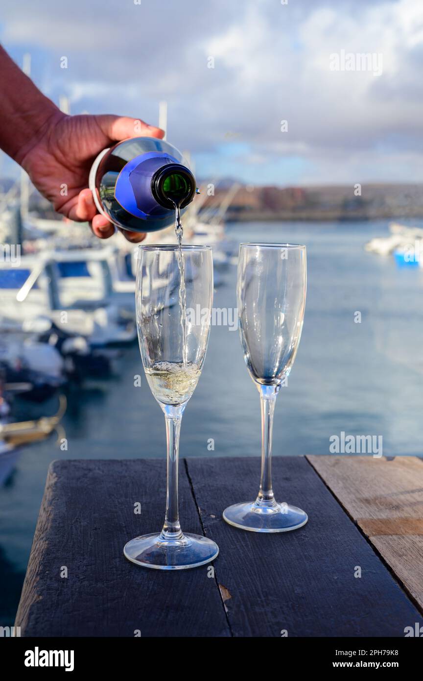 Everyday party, pouring of cava or champagne sparkling wine in glasses ...