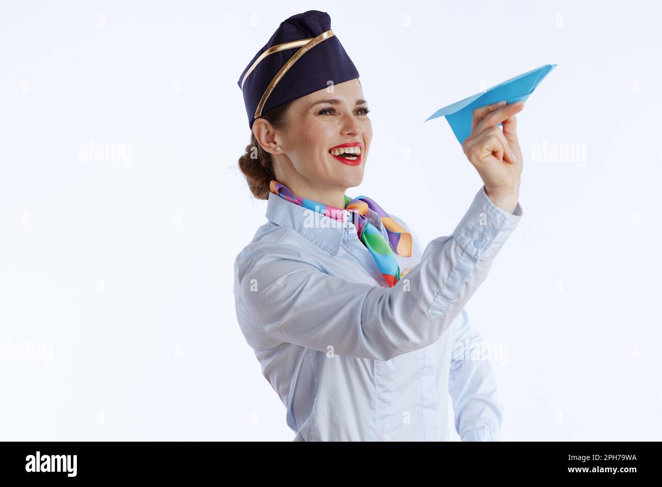 happy stylish female flight attendant against white background in ...