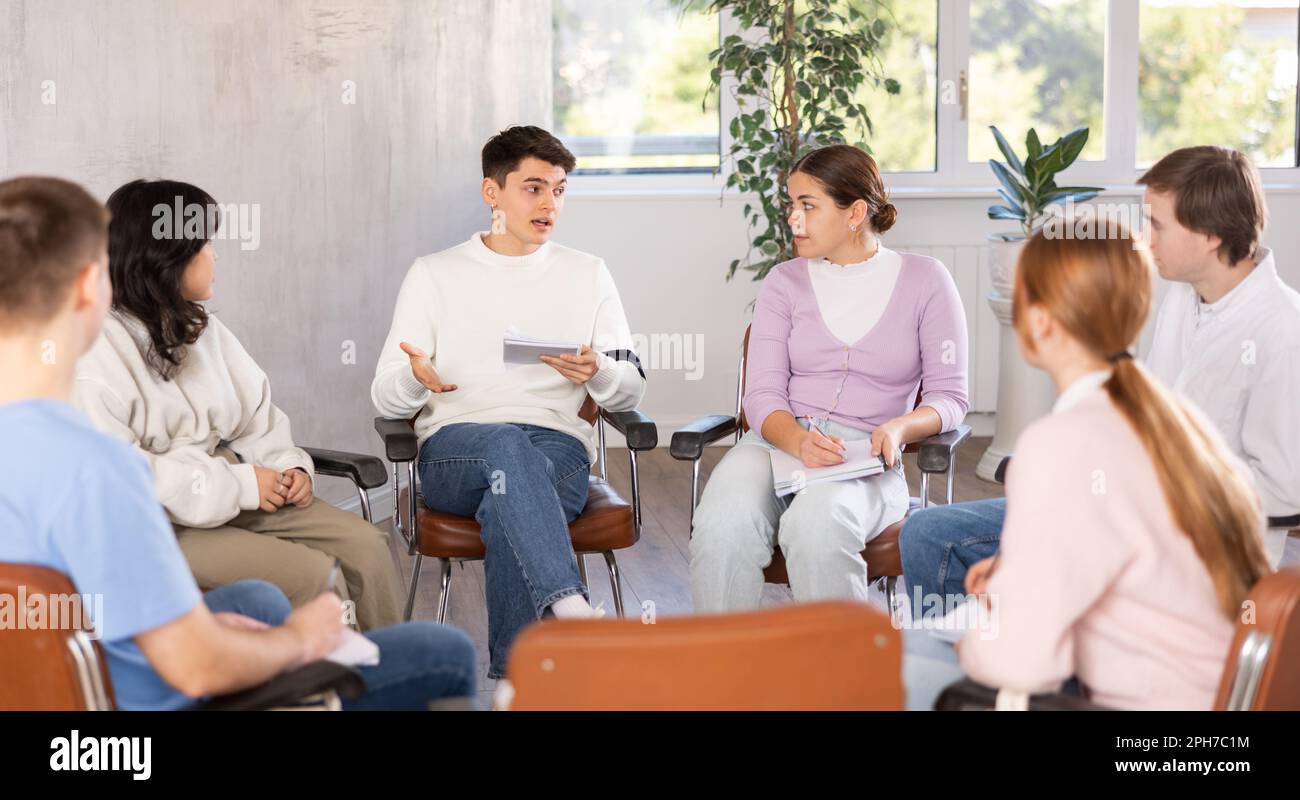 Young man teacher conducting lesson with group of students Stock Photo ...