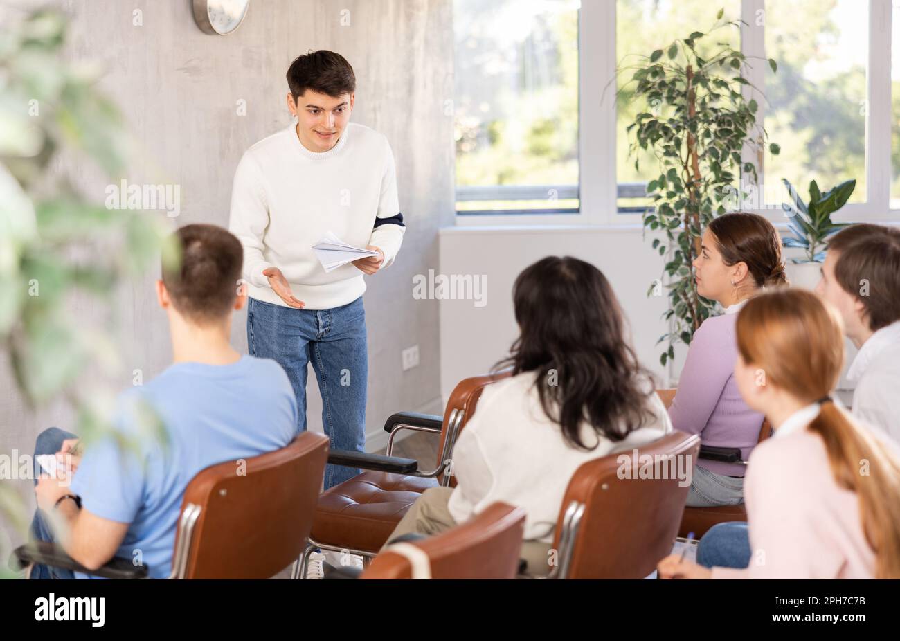 Young man teacher conducting lesson with group of students Stock Photo ...