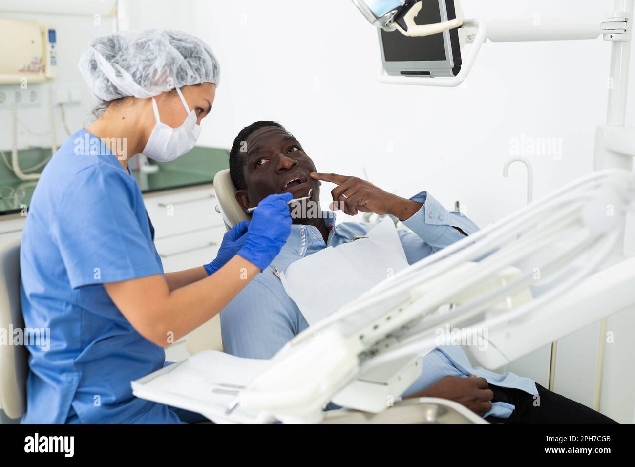 Patient complaining to doctor dentist about toothache Stock Photo - Alamy