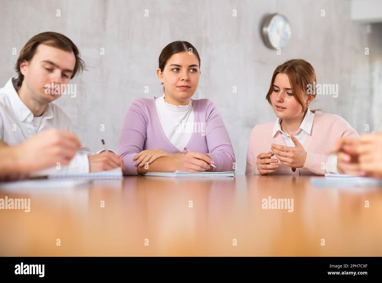 Young female student taking part in group discussion with coursemates ...