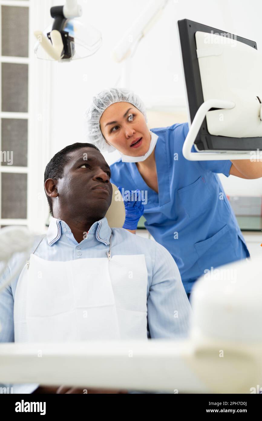 Doctor dentist shows patient an x-ray Stock Photo - Alamy