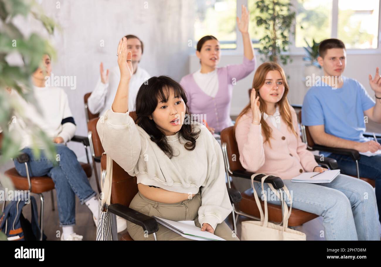 Young Asian female student raising hand to answer at lecture Stock ...