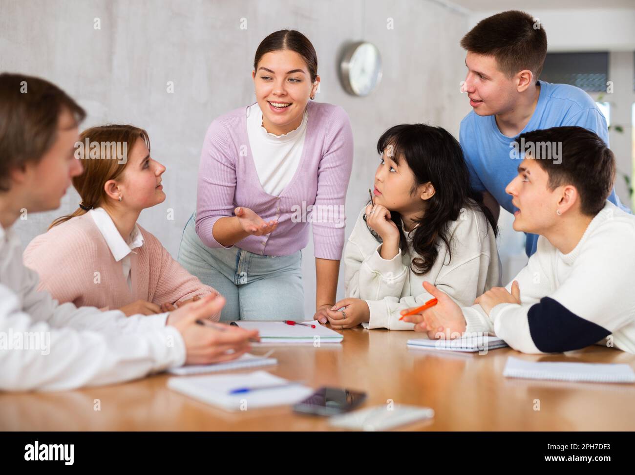 Young female teacher giving lecture to group of students Stock Photo ...