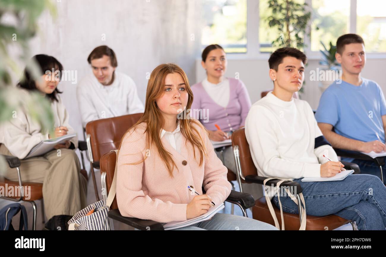 Positive female student attending training session in lecture class ...