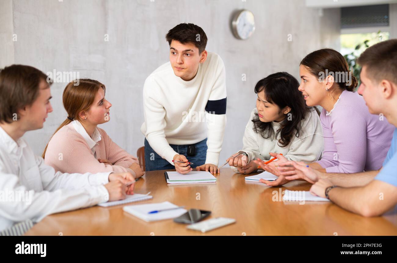 Positive guy team leader holding meeting with group of students Stock ...