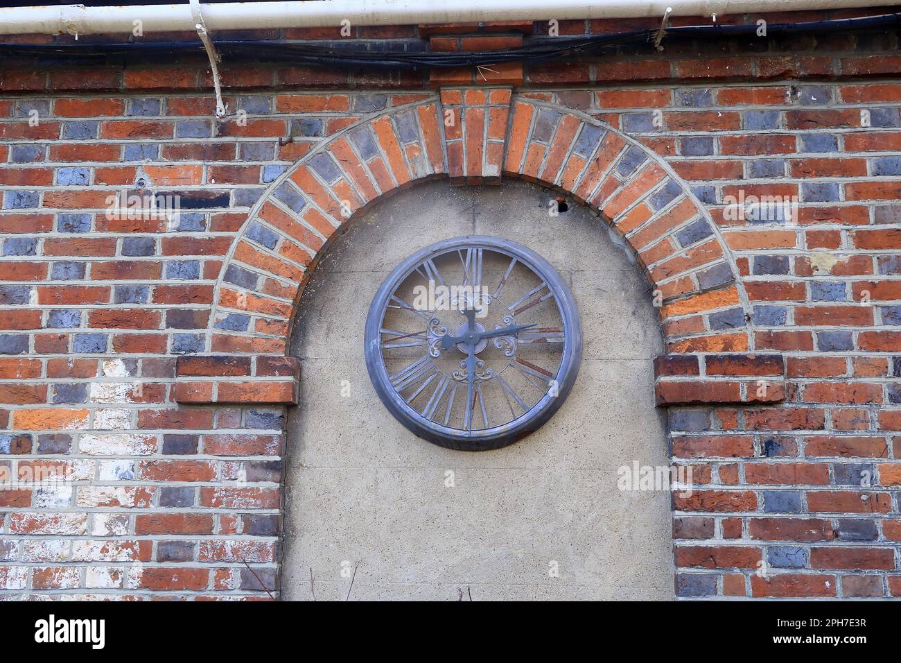 A rusty old clock face under a brick arch Stock Photo - Alamy