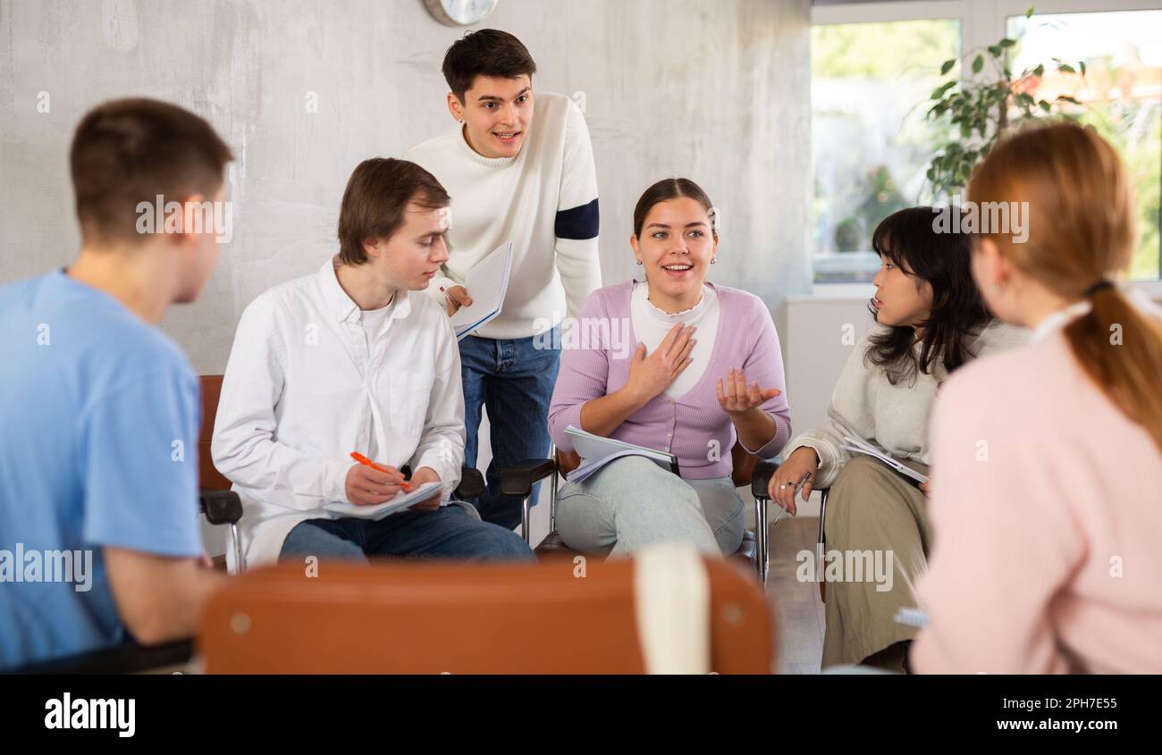 Group of students engaged in discussion in classroom Stock Photo - Alamy