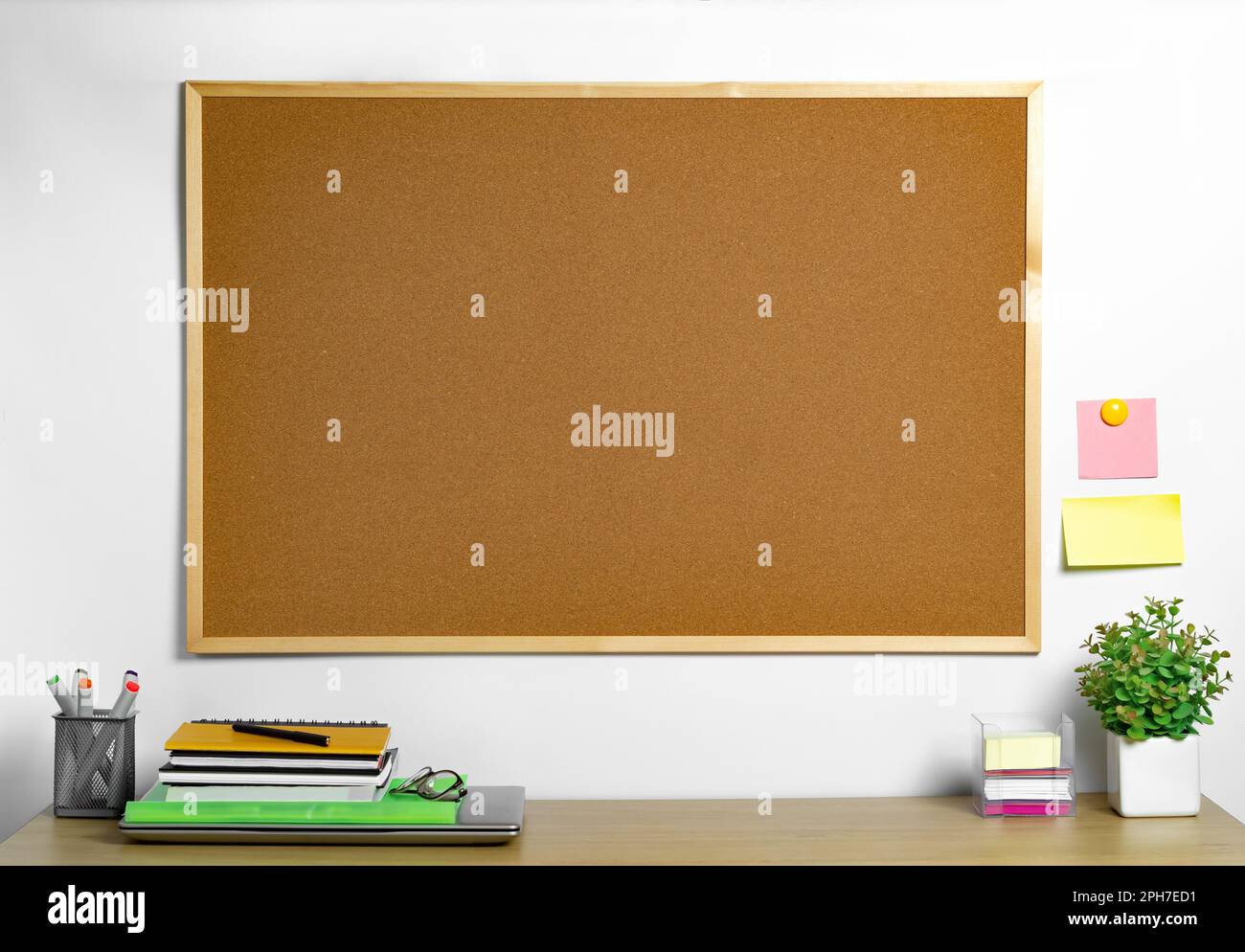 Empty cork board with wood frame over work desk. Place for notes and ...