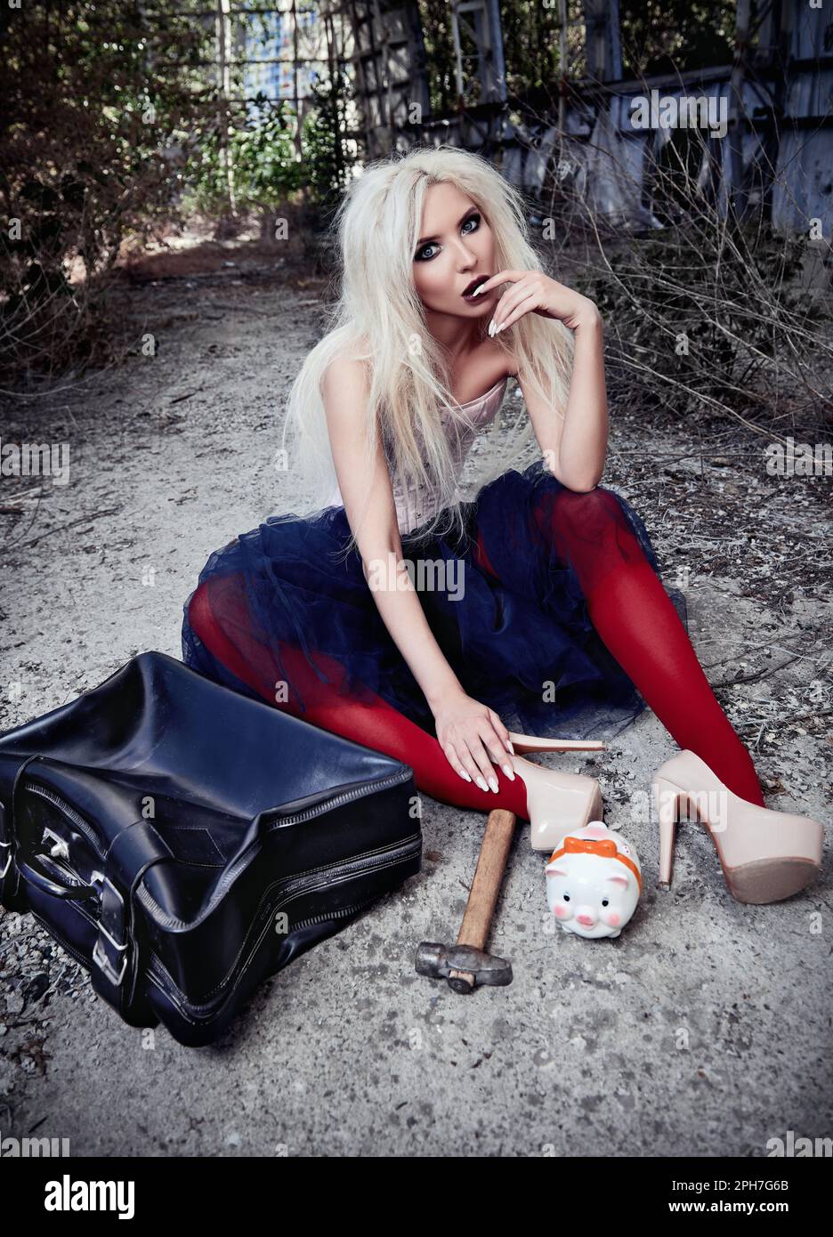 Portrait of the sad weird freak girl with suitcase, hammer and money ...