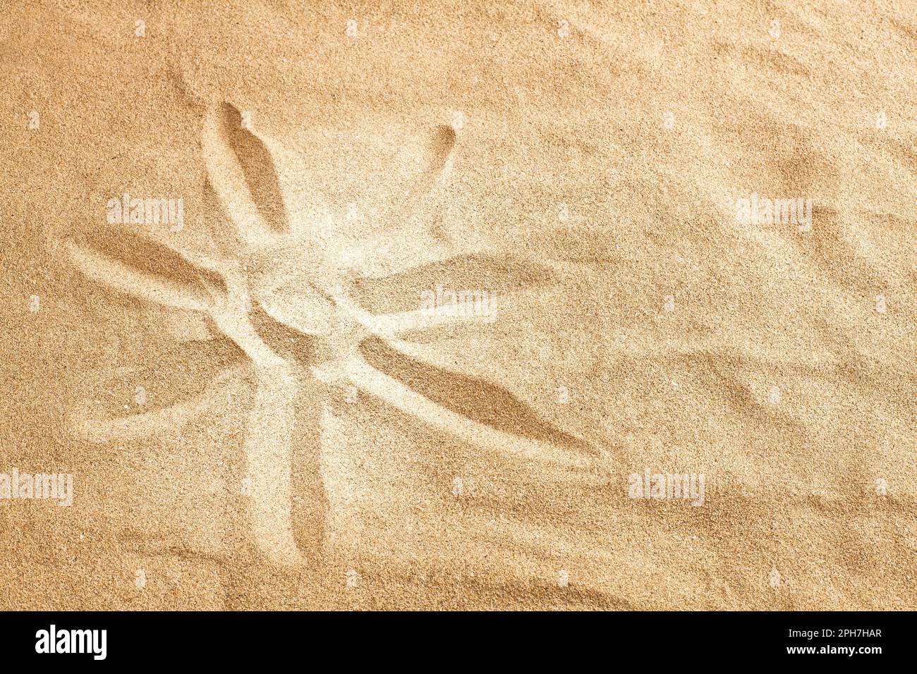 Finger drawing a sun on the sunny summer sand. Vacation and holidays ...