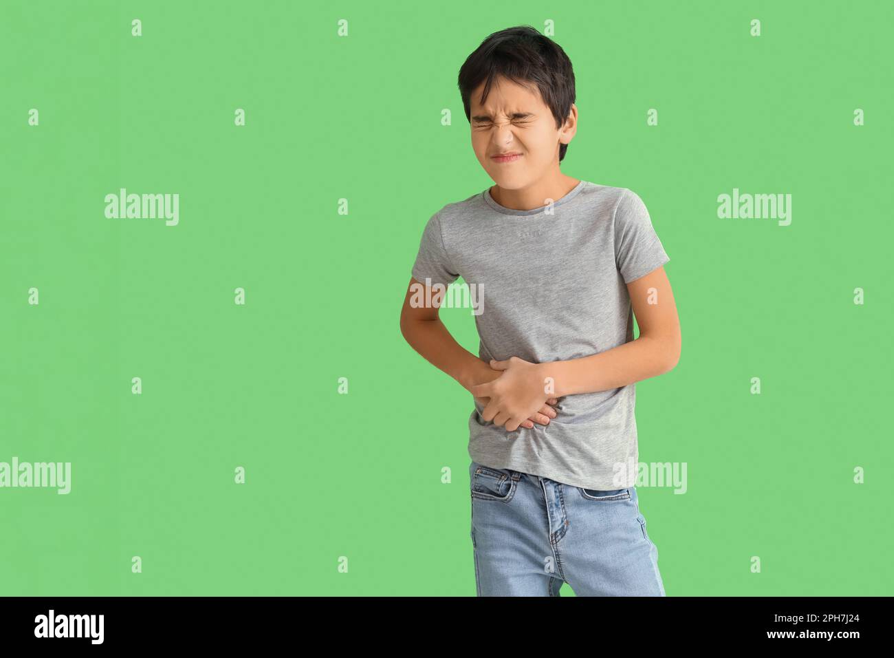 Little boy with appendicitis on green background Stock Photo - Alamy