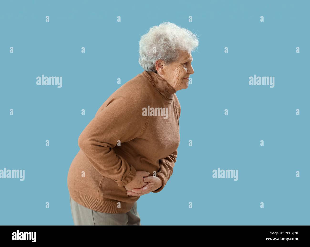 Senior woman with appendicitis on green background Stock Photo - Alamy