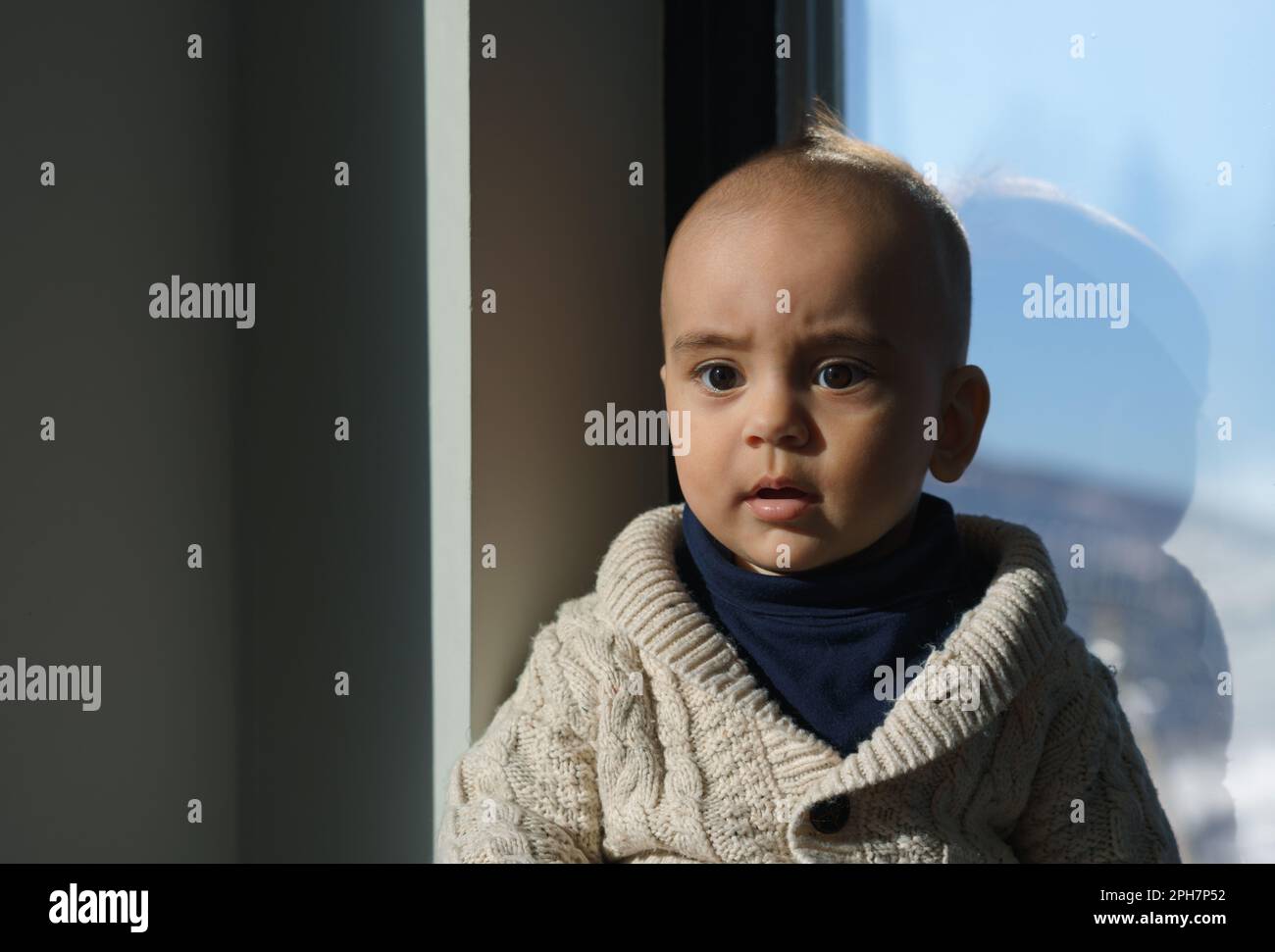 Portrait of a Confused kid sitting beside the window Stock Photo - Alamy