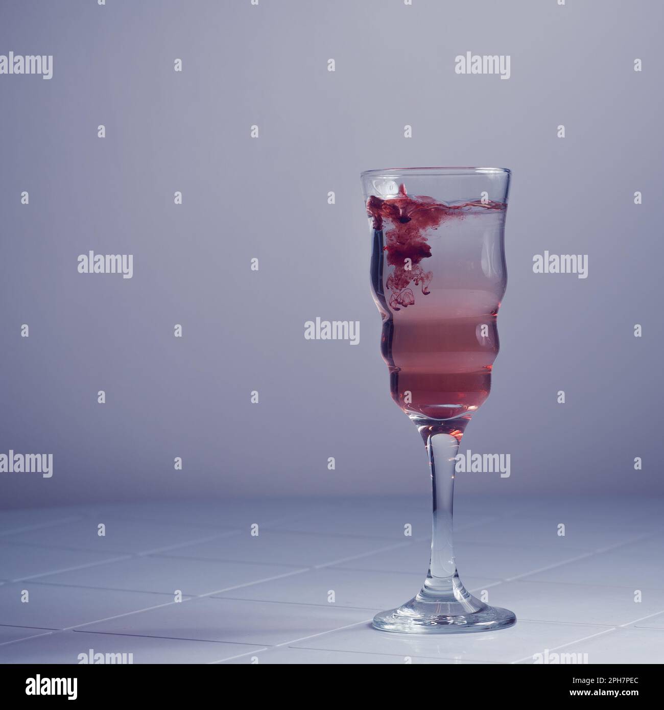 glass cup with red ink drop Stock Photo - Alamy