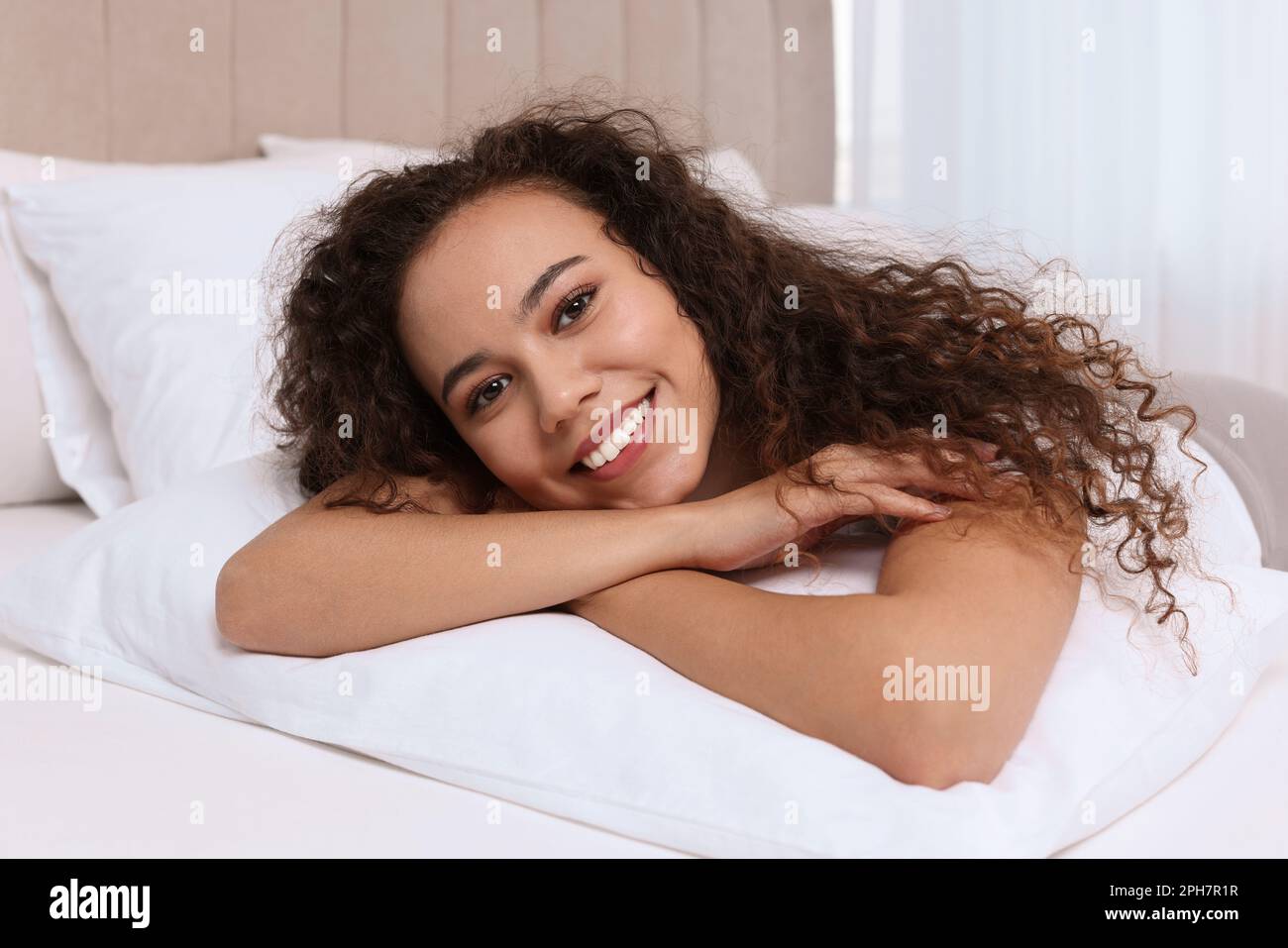 Happy African American woman lying on bed at home Stock Photo - Alamy