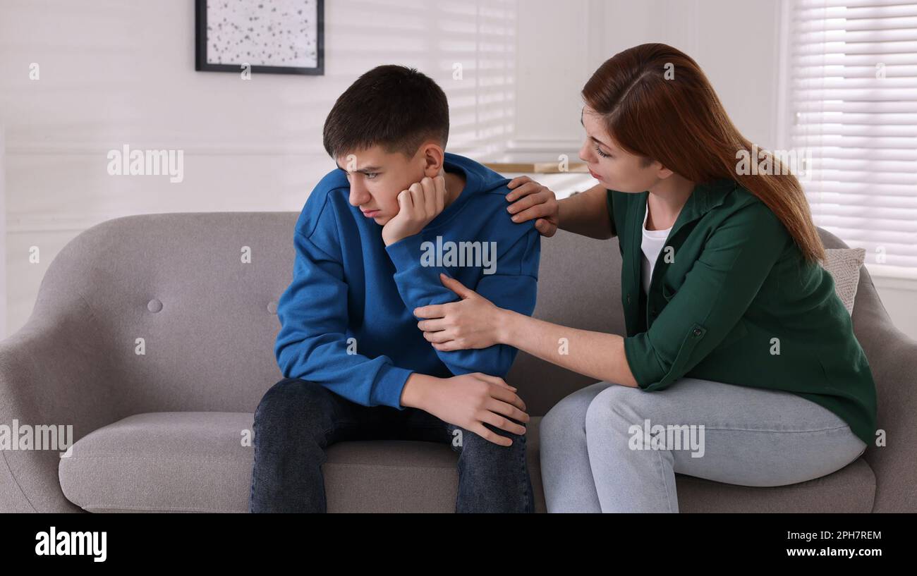 Mother consoling her depressed son at home. Teenager problems Stock ...
