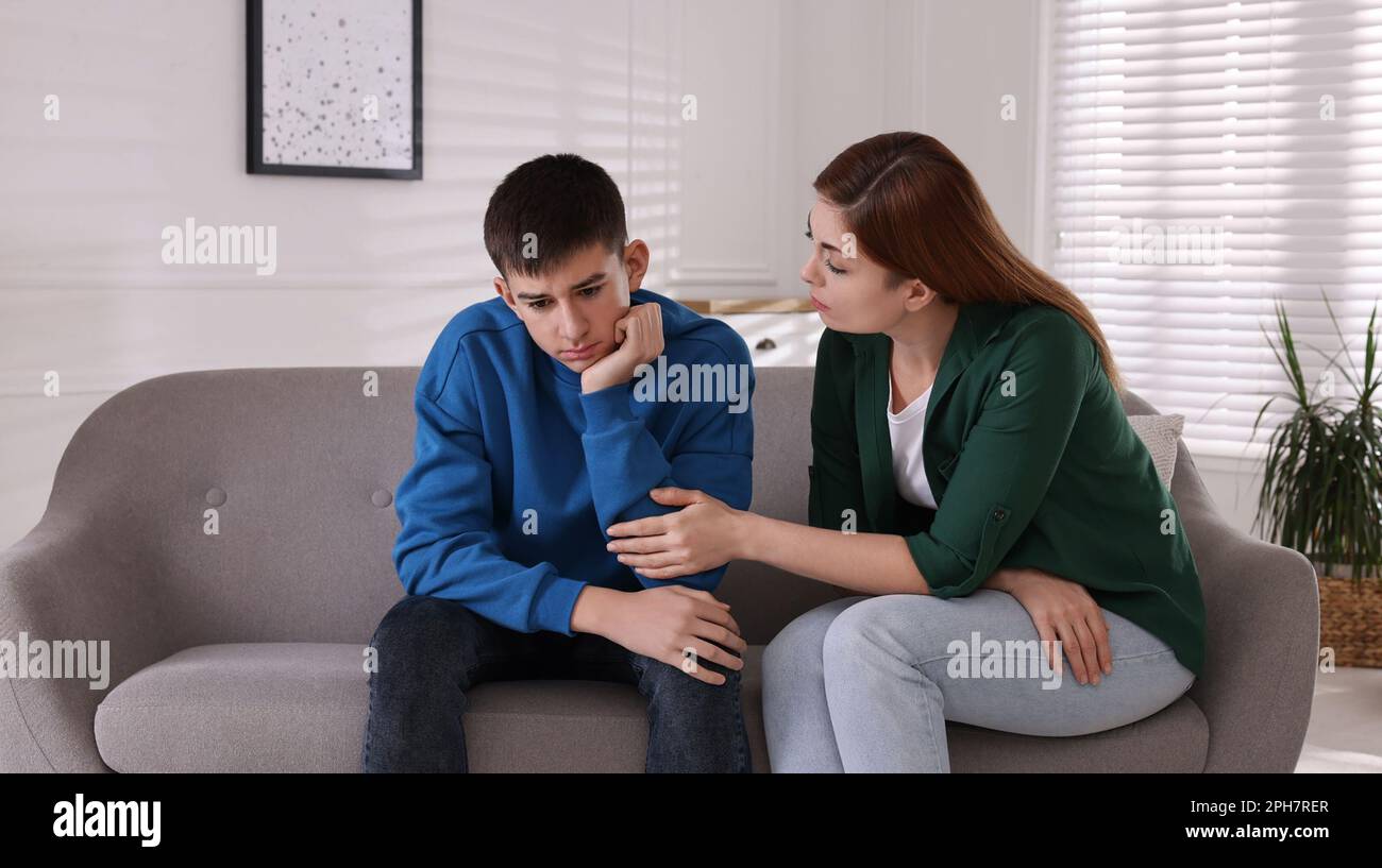 Mother consoling her depressed son at home. Teenager problems Stock ...
