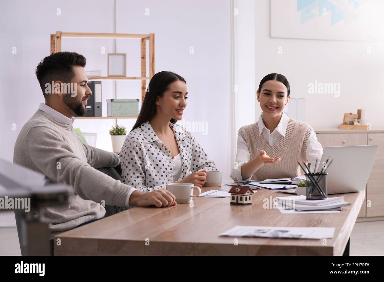 Real estate agent working with young couple in office. Mortgage concept ...