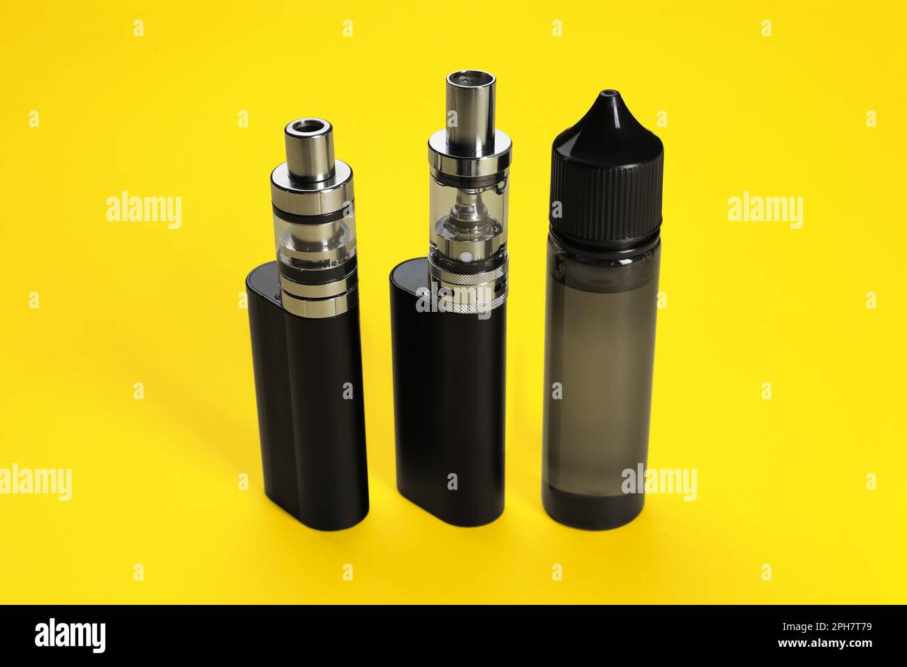 New reusable electronic cigarettes and vaping liquid on yellow ...