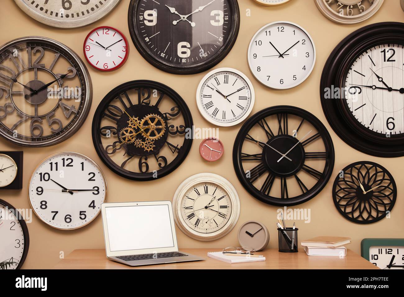 Collection of wall clocks over workplace indoors Stock Photo - Alamy