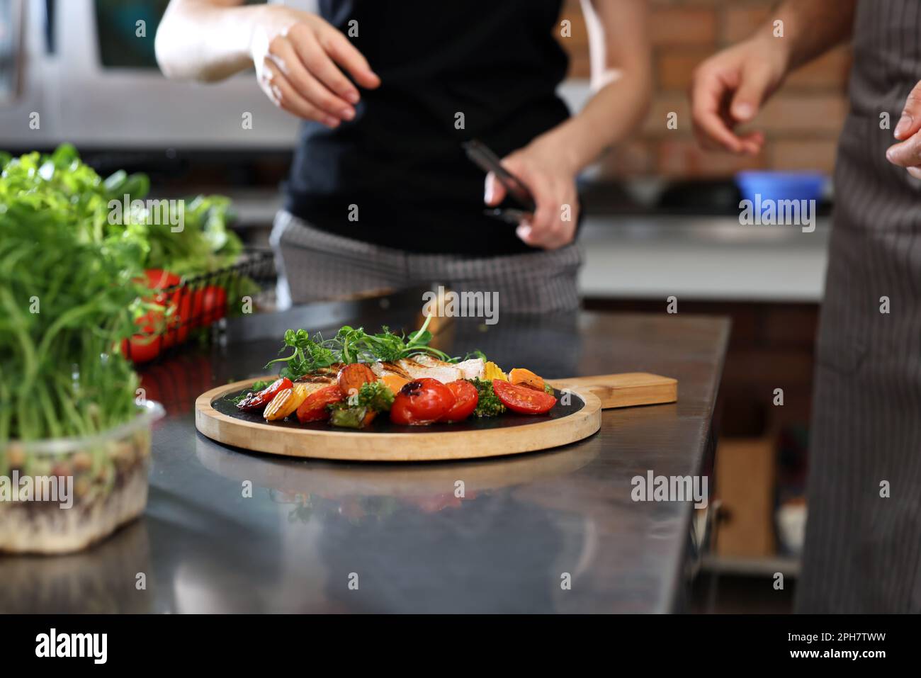 Professional chefs in restaurant kitchen, focus on table with delicious ...