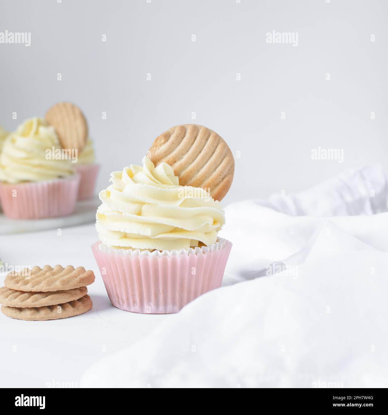 Pink cupcakes with tall american buttercream swirl and cookie garnish ...