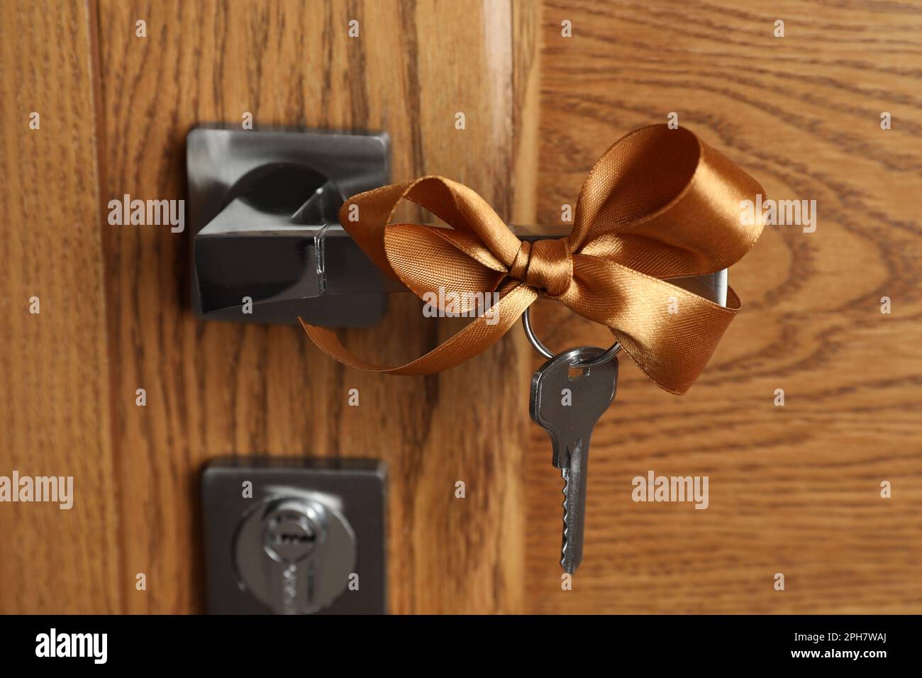Key with bow on door handle, closeup view. Housewarming party Stock ...