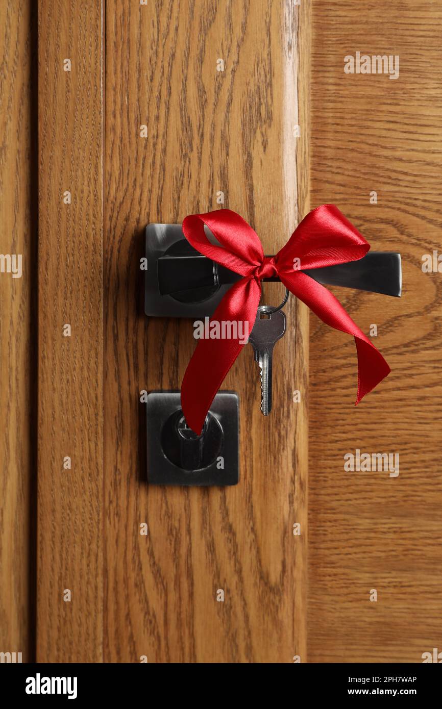 Key with red bow on door handle. Housewarming party Stock Photo - Alamy