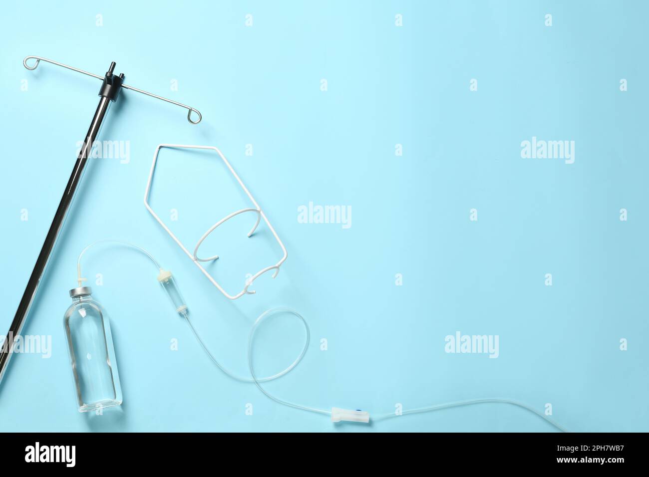 IV infusion set on light blue background, flat lay. Space for text ...