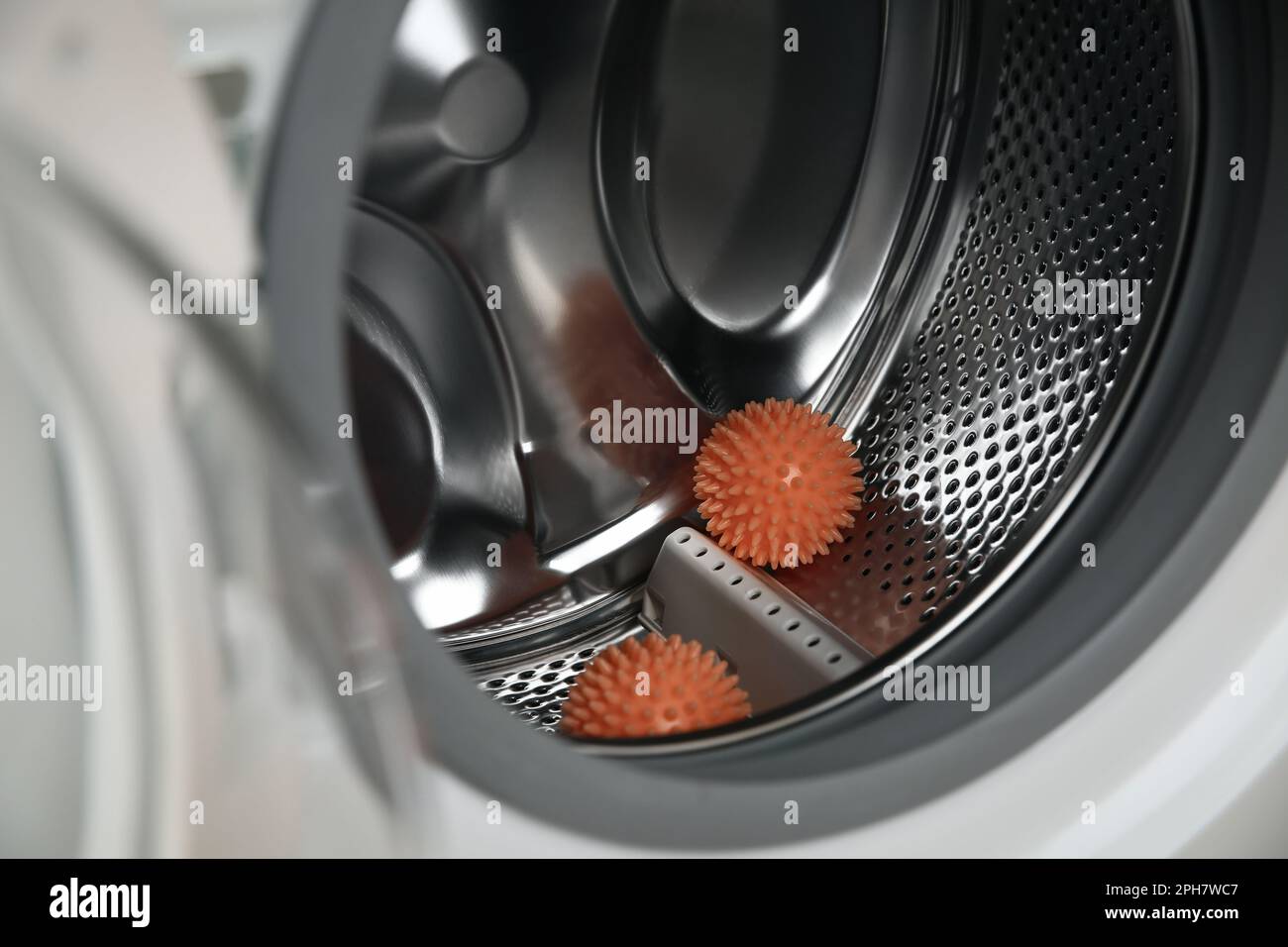 Dryer balls in washing machine drum, closeup Stock Photo - Alamy